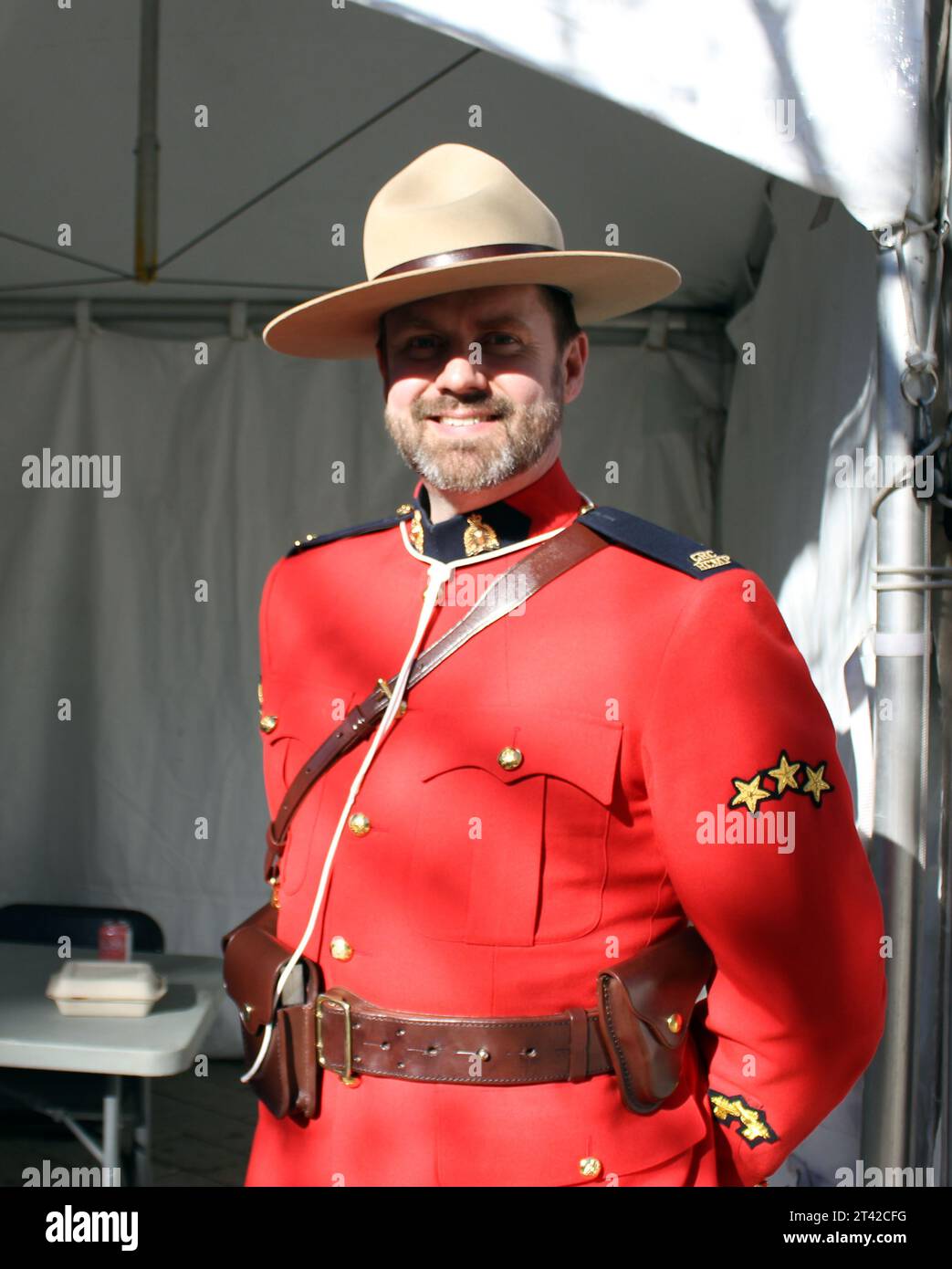 A Young Male Soldier Stands Dressed In Full Military Gear Wearing A Hat And Facing A Large