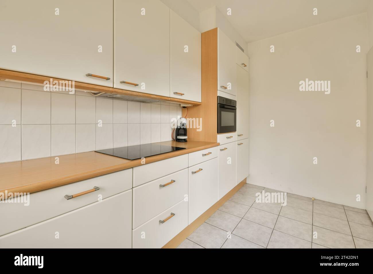 a kitchen with white cupboards and wood counter tops on the counters in ...