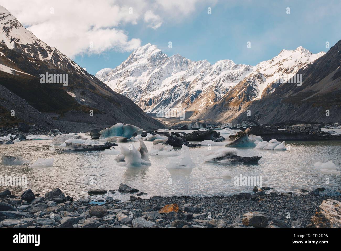 An idyllic winter scene of ice chunks in a river with Mt Cook in the ...