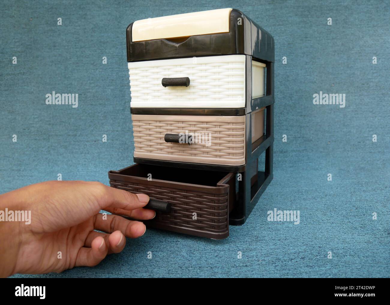 Man's hand is opening a pastel cream office storage plastic box on an ...