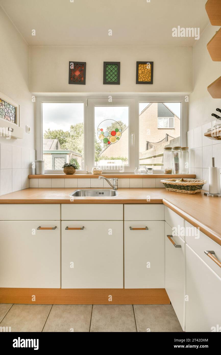 a kitchen with white cupboards and wood counter tops in front of the ...