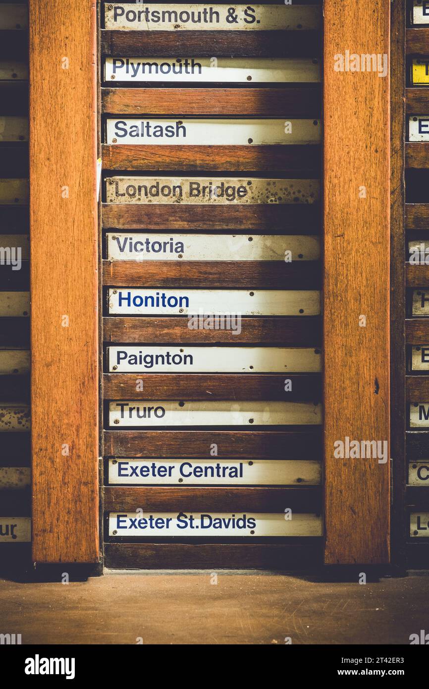 A horizontal wooden wall with directional signs attached to it ...