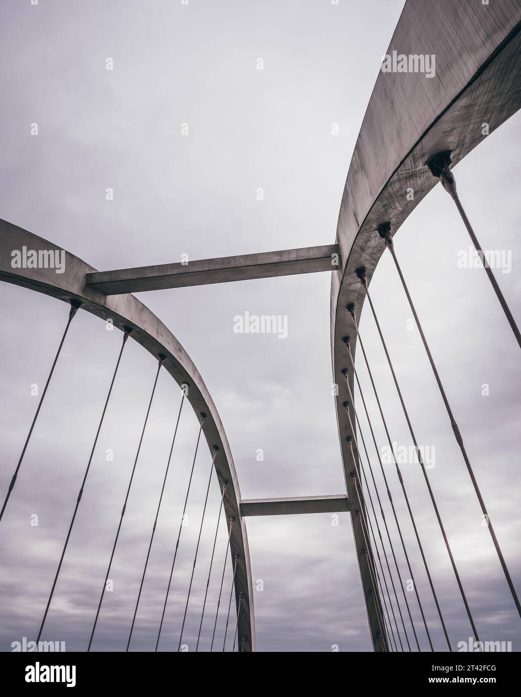 A shot of the top of a curved bridge, showing the metal structure and ...