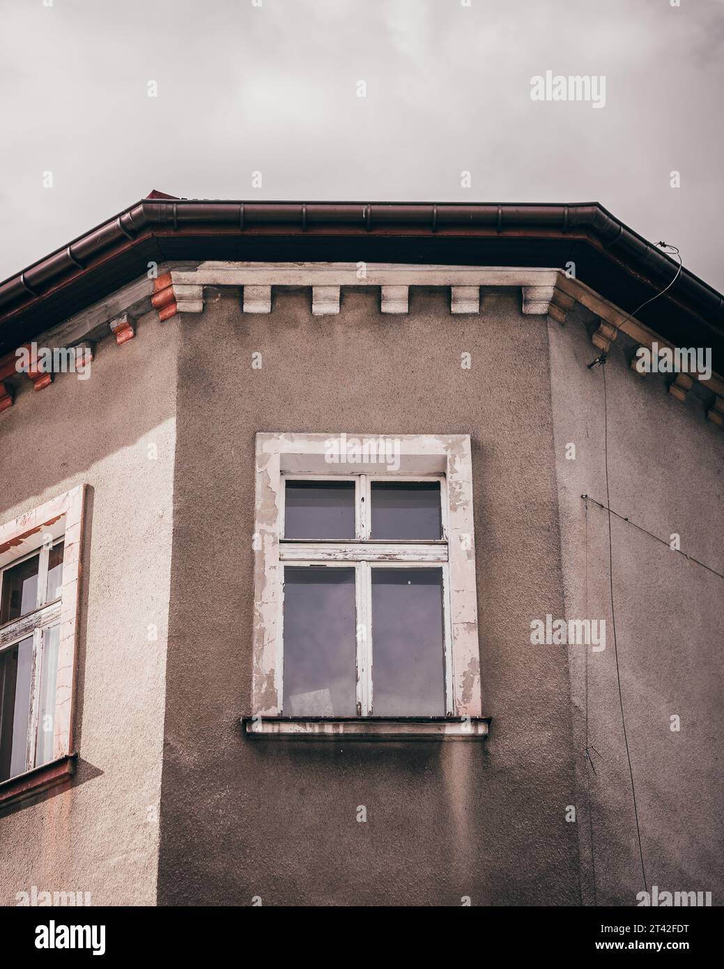 An aged structure featuring multiple windows in its uppermost section ...