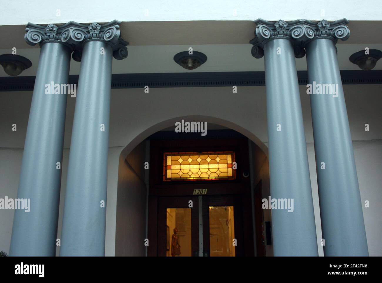 An impressive wooden entrance with three ornately carved pillars and a ...