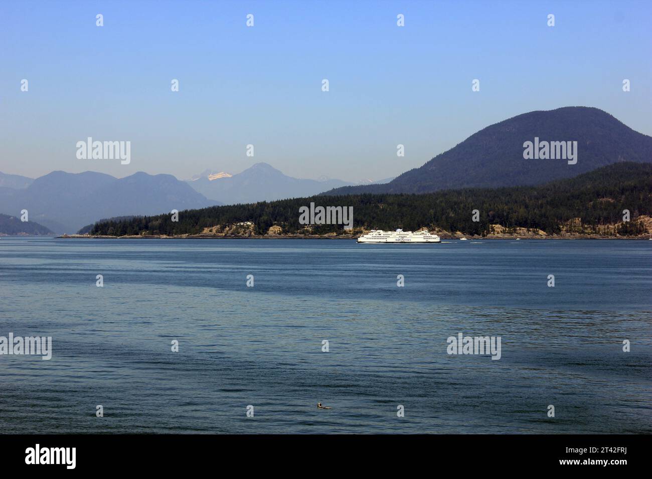A luxurious white boat is moored in a tranquil mountain lake, with ...