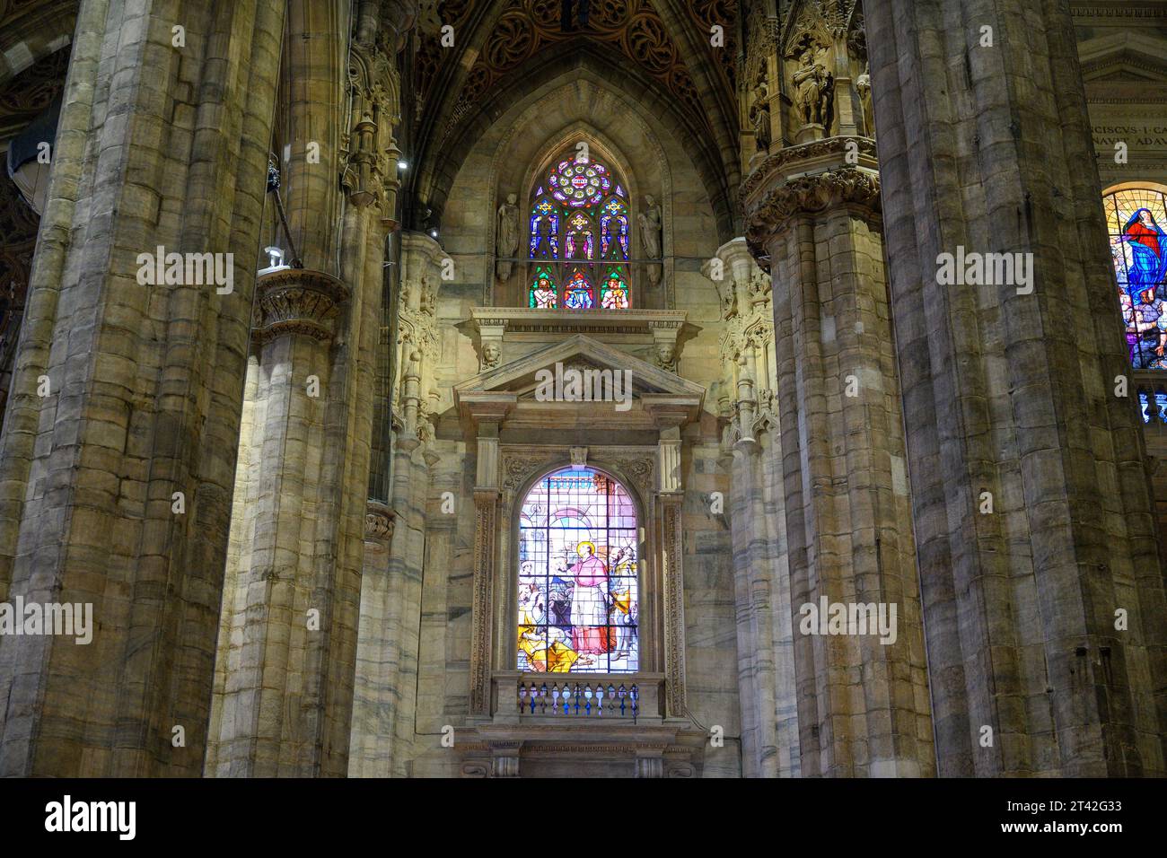 Large glass stained windows and the various large, stone columns within ...