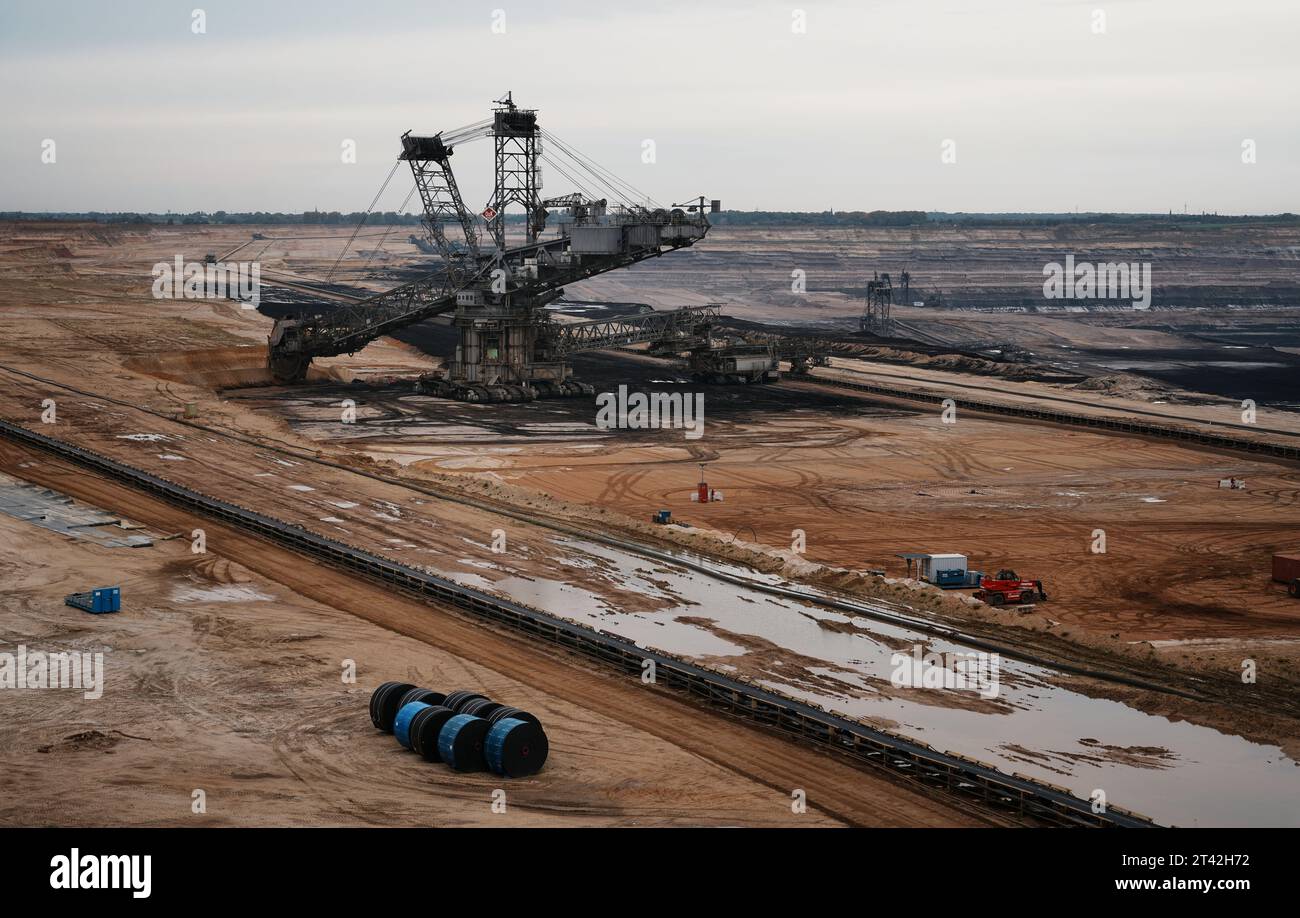 An immense brown coal excavator in an opencast mine in the foreground ...