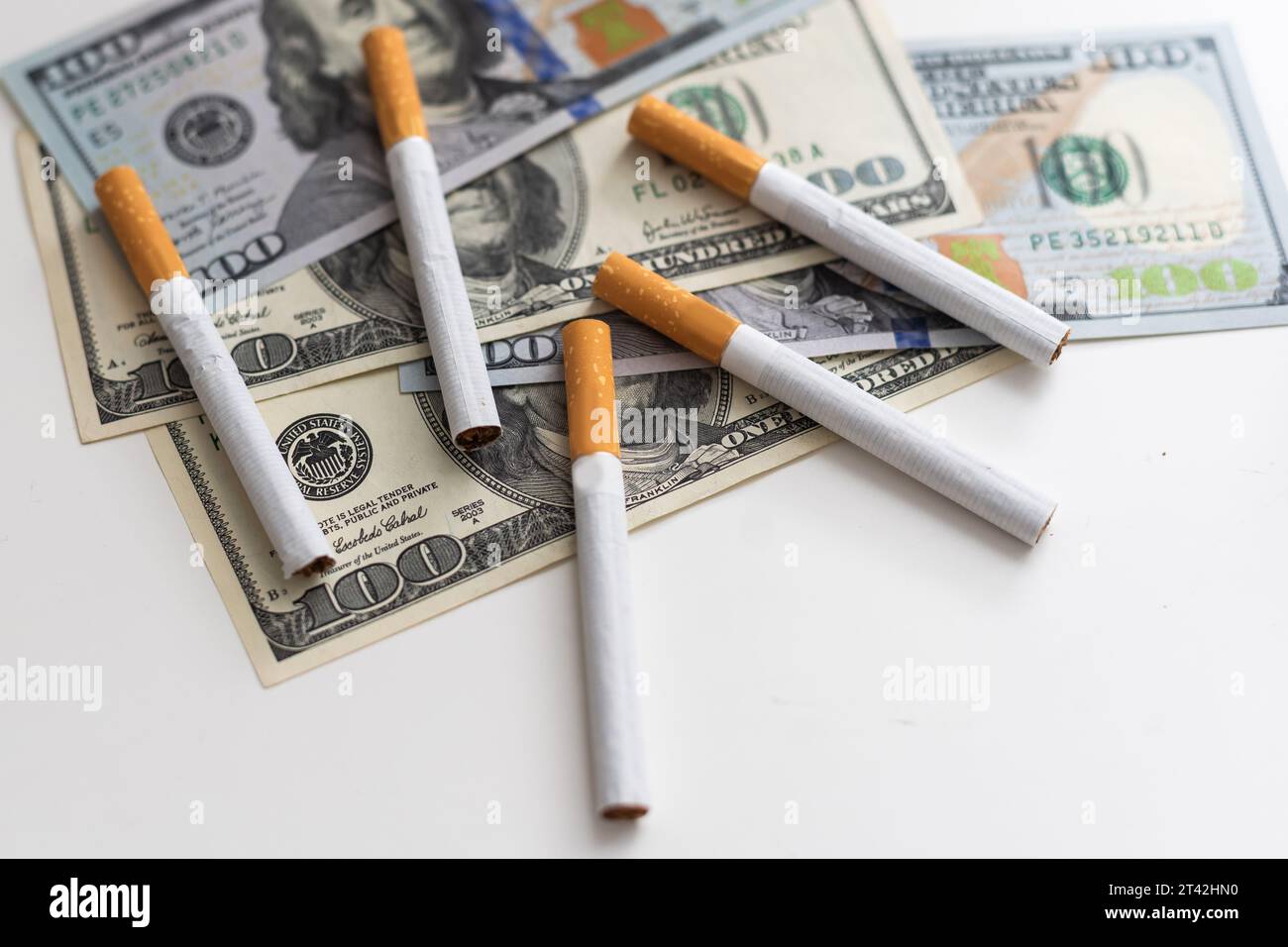 Smoking and money cost. Cigarettes on hundred dollar banknotes ...