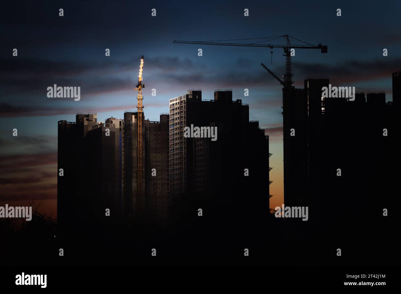 Tower crane at building and apartment construction site, dark night ...