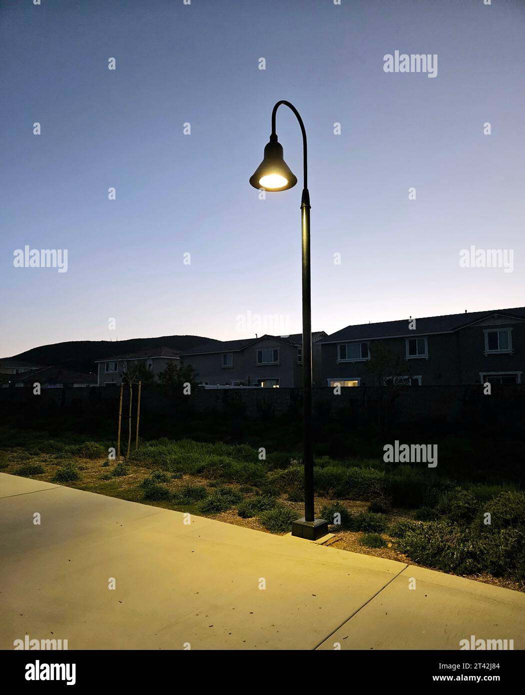 This image depicts a suburban street lit up by a single street lamp at ...