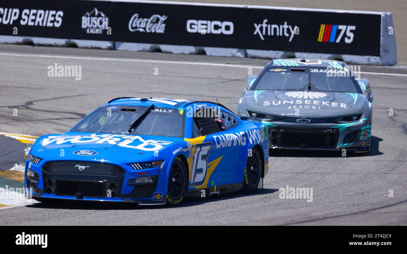A car race track with two vehicles in mid-race, and a third car lined ...