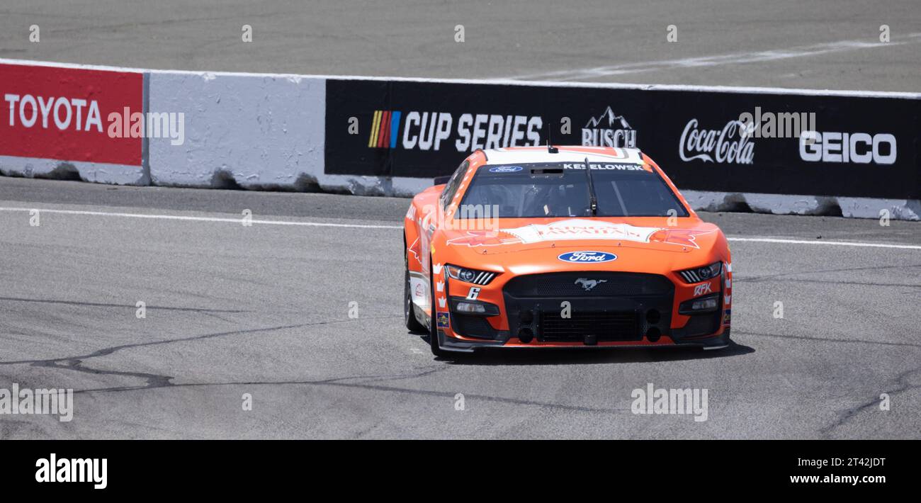 High-speed race car driving along a track in a bright orange color ...