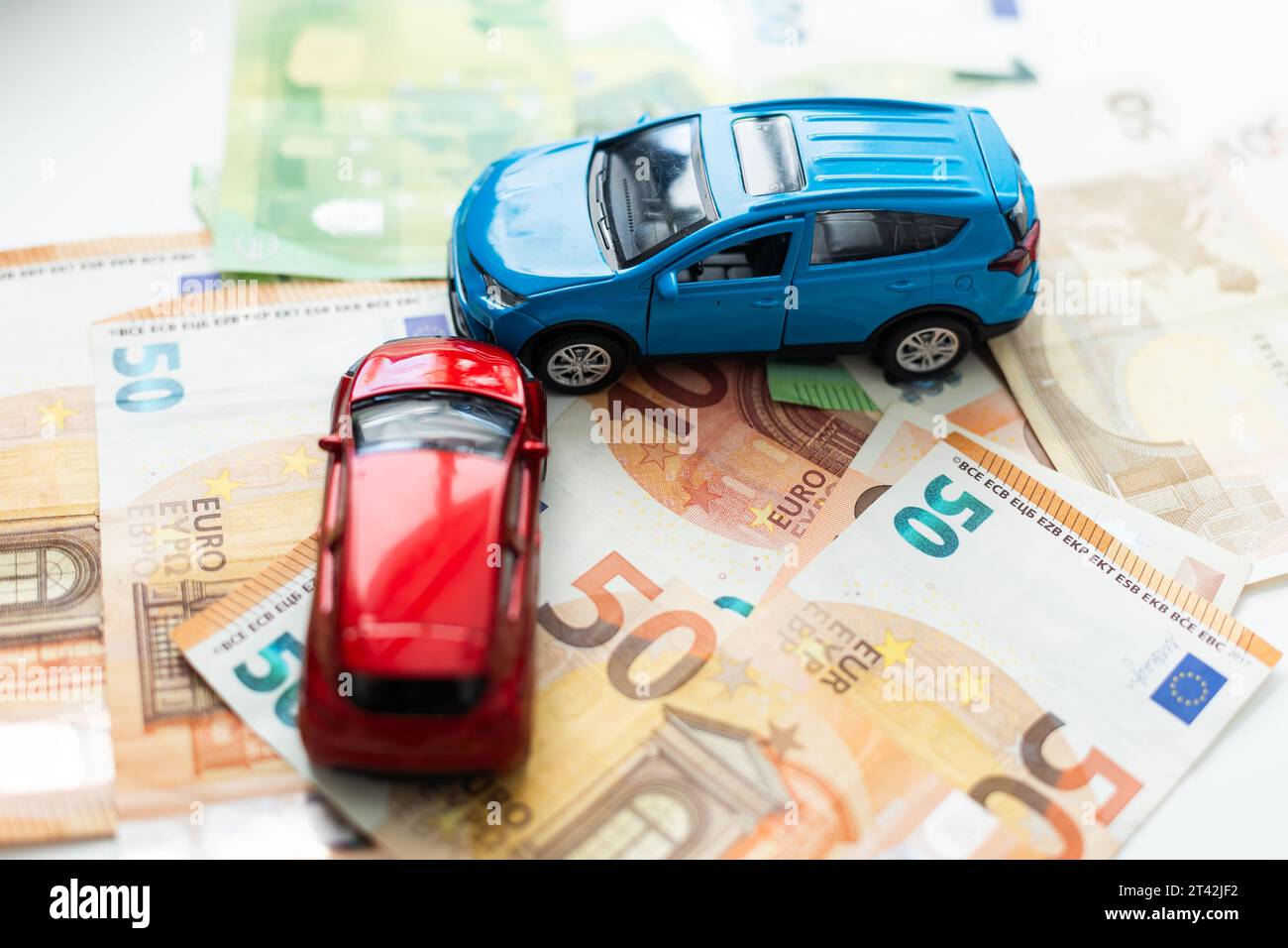 two cars with euro bills, notepad and pen Stock Photo - Alamy