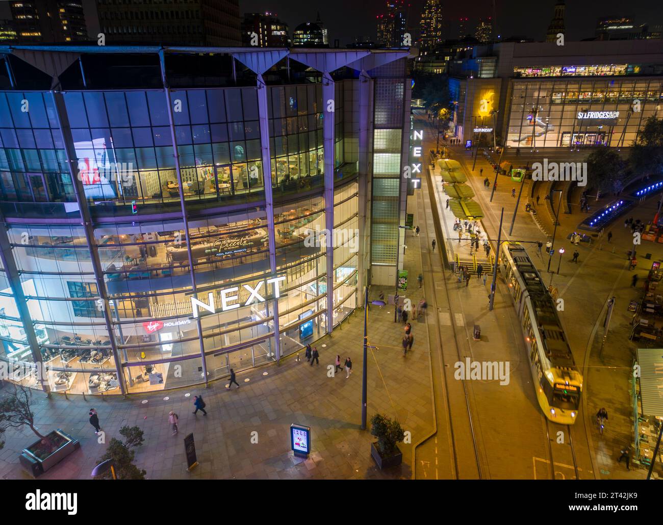 Tram passes NEXT store illuminated at night in Exchange Square ...
