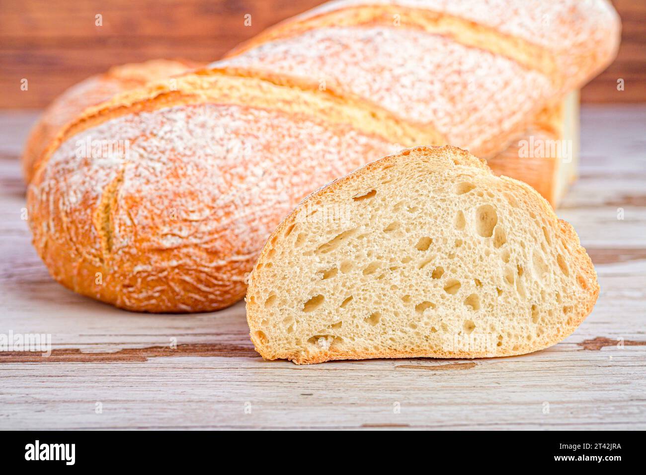 Several white bread slices, one partially cut in half with a knife ...
