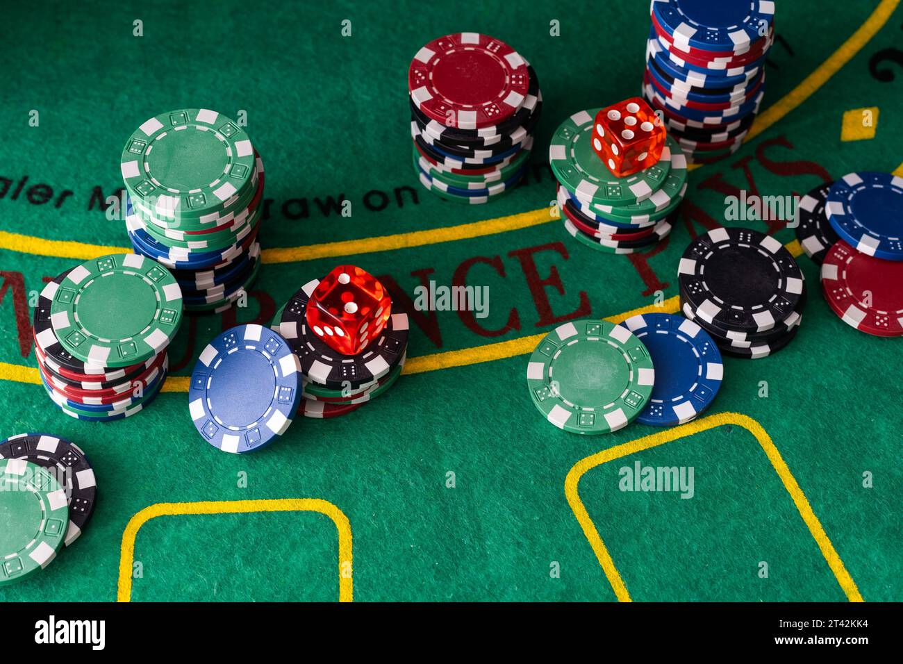 on the green poker table are playing cards, and lots of colored chips ...