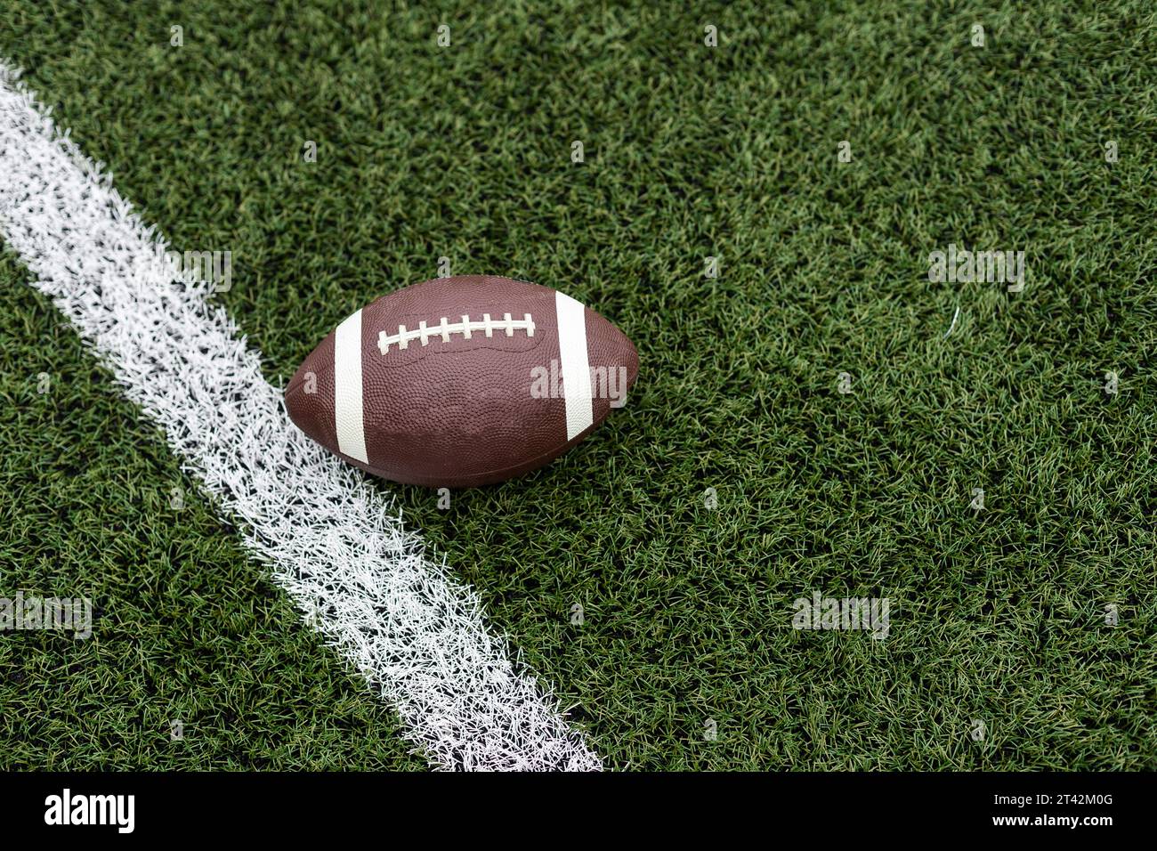Football by a yard marker on a football field Stock Photo - Alamy
