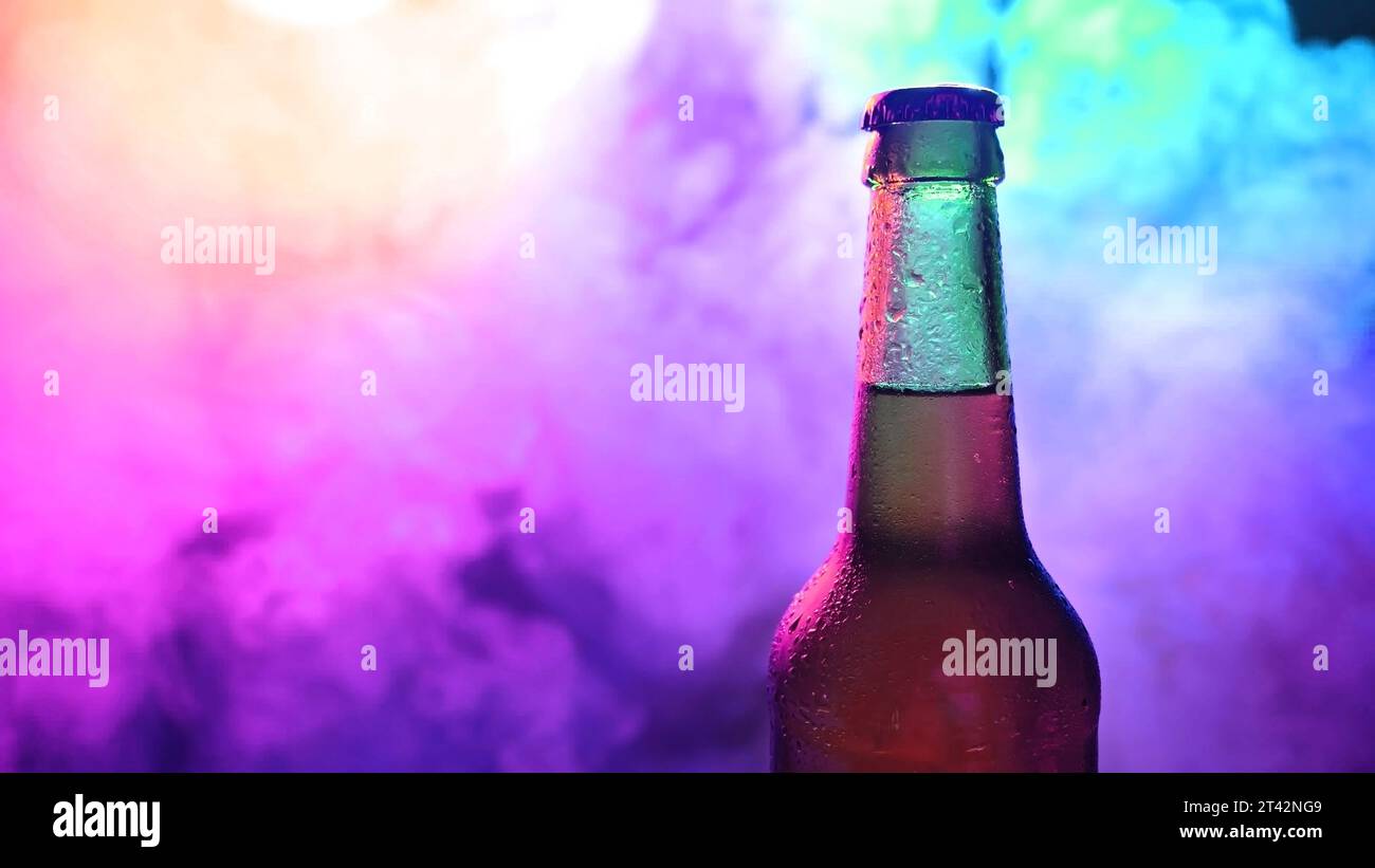 Beer bottle spinning in blue pink smoke Stock Photo - Alamy