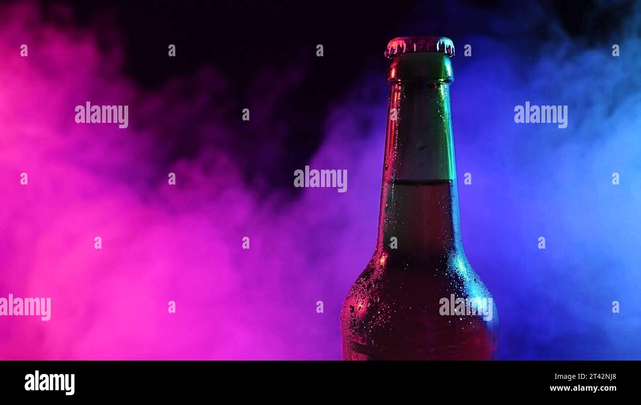 Beer bottle spinning in blue pink smoke Stock Photo - Alamy