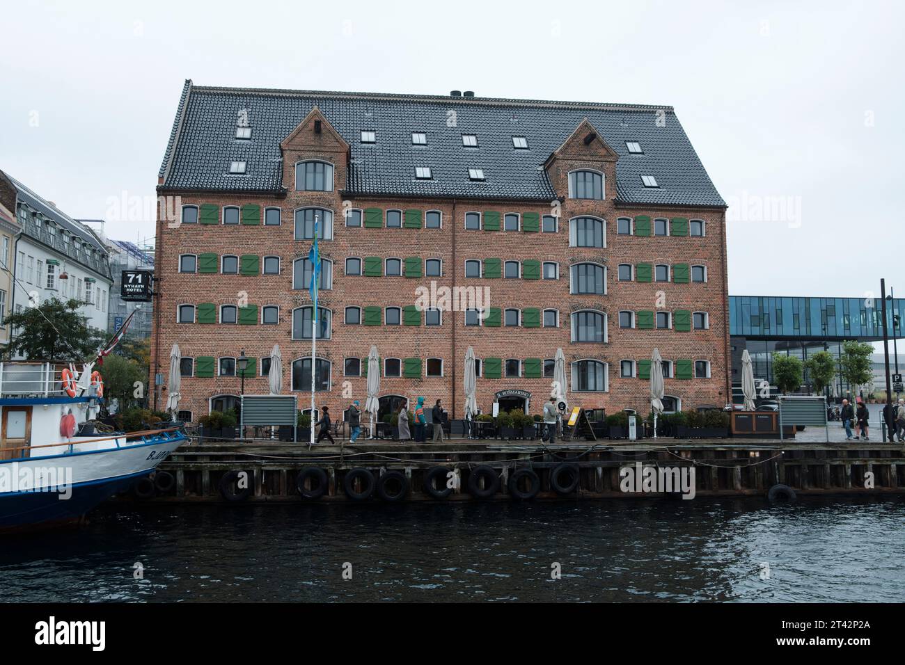 A majestic brick building stands overlooking a tranquil body of water ...