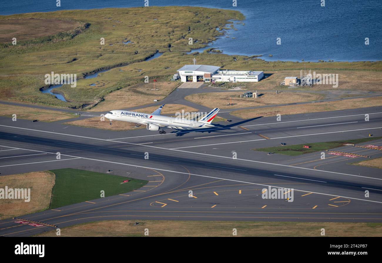 This image depicts an airplane positioned on a runway beside a tranquil ...