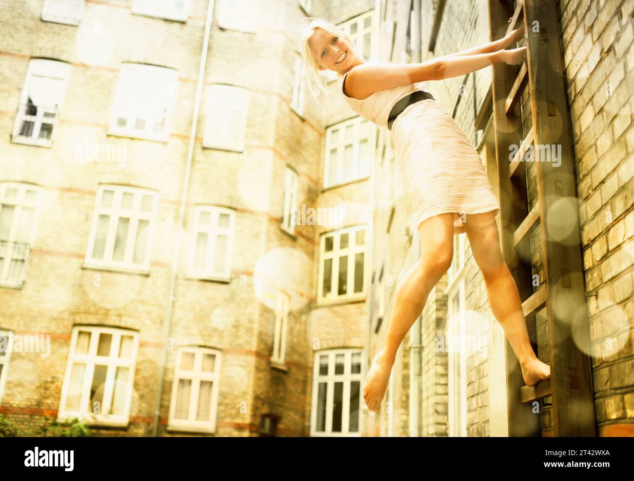 Portrait, smile and a woman on a ladder in an old city with flare for ...