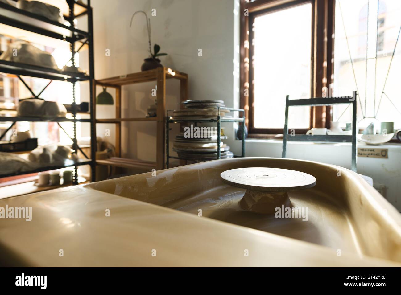 Potter's wheel, shelves and windows in pottery studio Stock Photo - Alamy