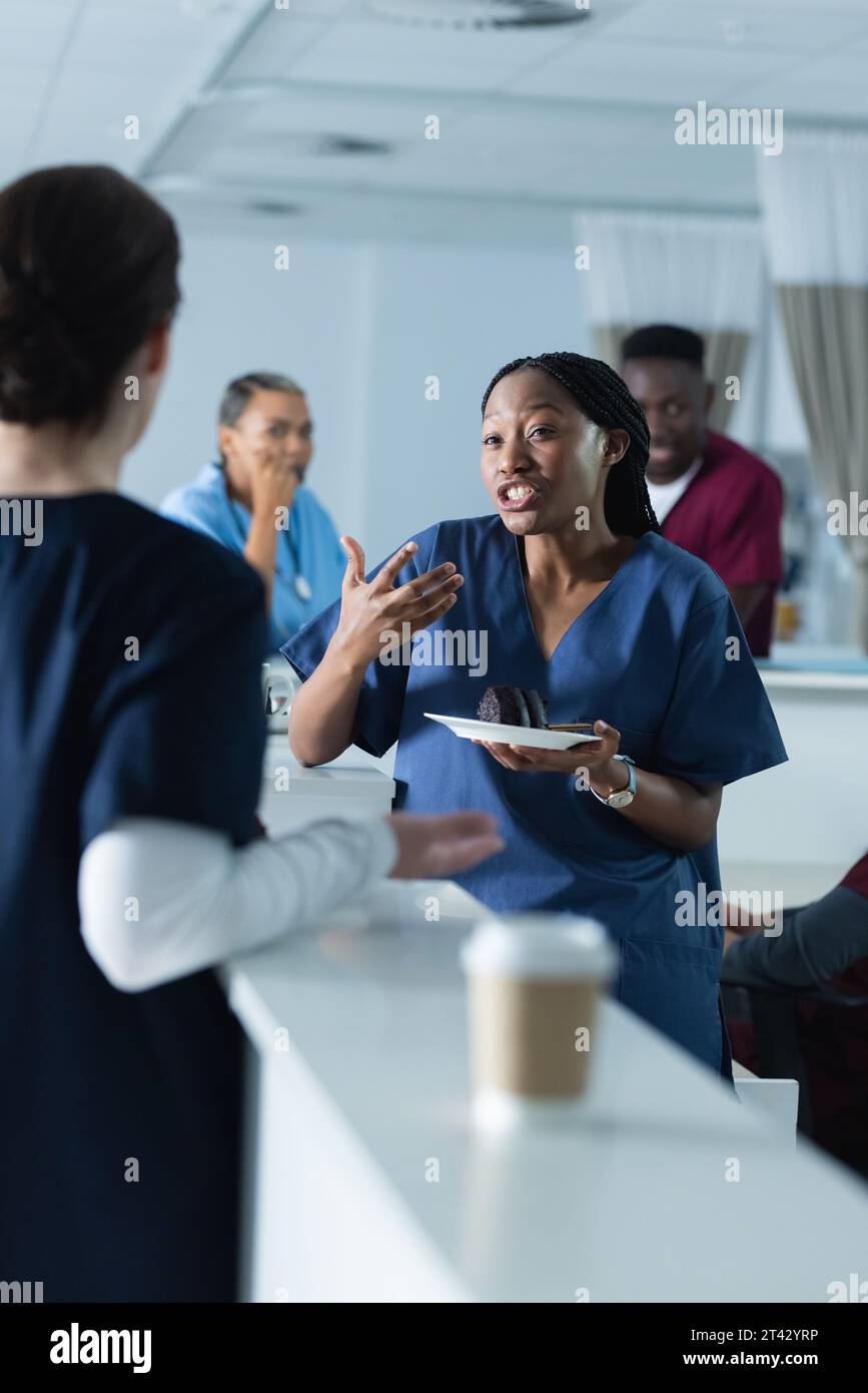 Happy diverse male and female doctors eating birthday cake at reception ...