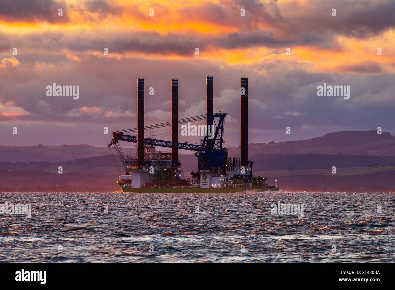Jack-up vessel Sea Challenger heading out to sea at sunset Stock Photo ...
