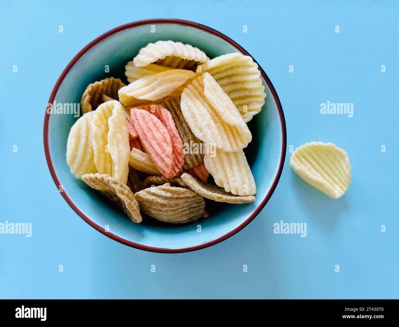 Overhead view of a bowl of assorted multi coloured vegetable crisps ...