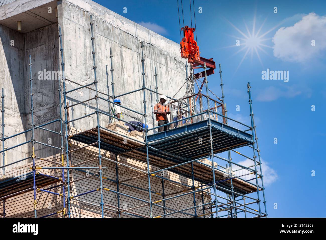 african american construction workers , on scaffolding on a concrete ...