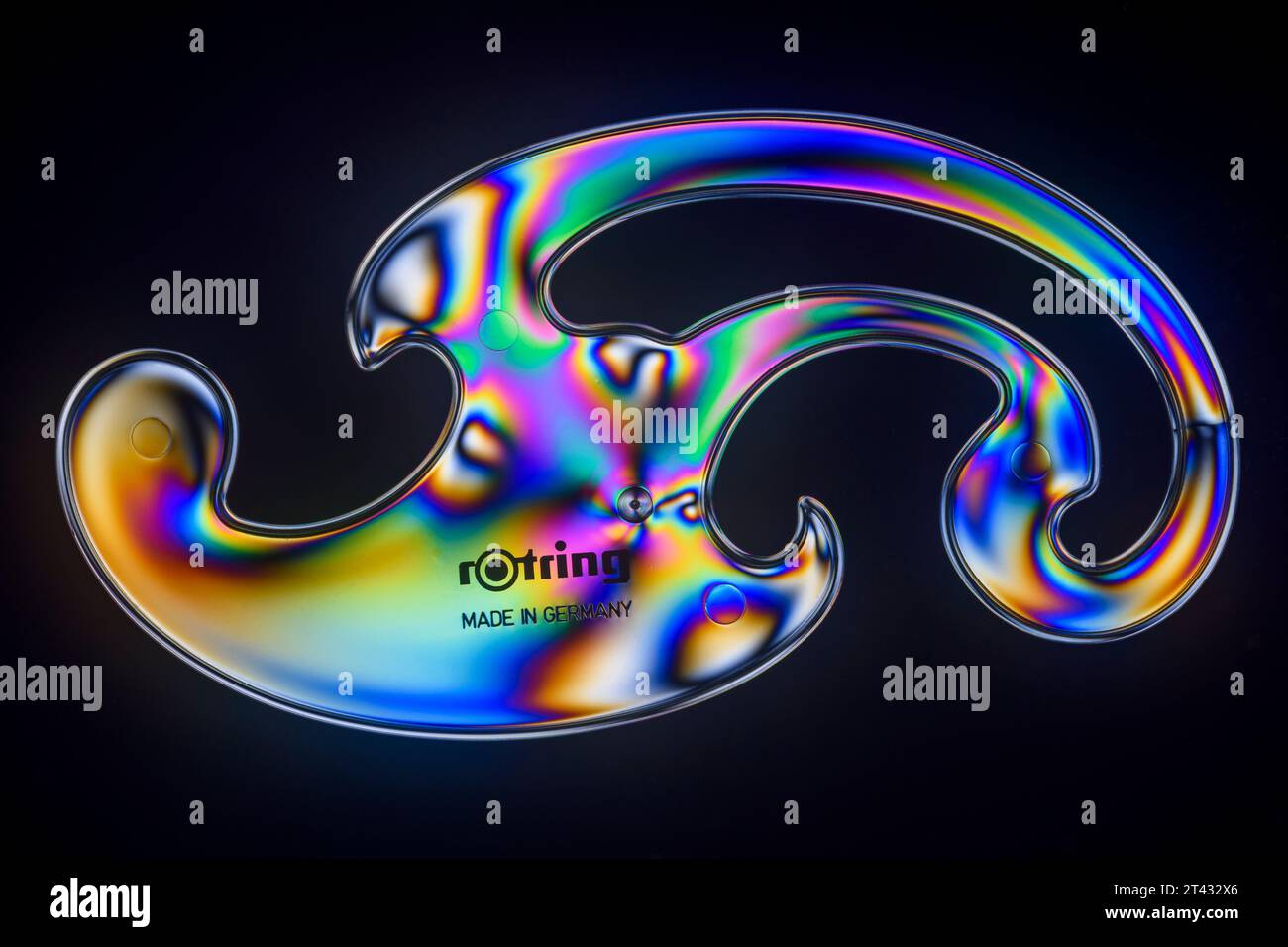 A Rotring clear plastic french curve drawing aid viewed between crossed ...