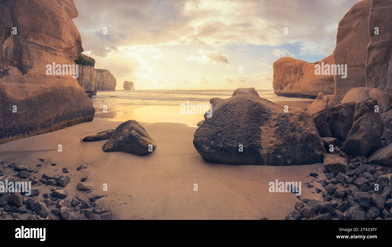 Rocky sandstone coastline and inlet at sunrise, South Island, New ...