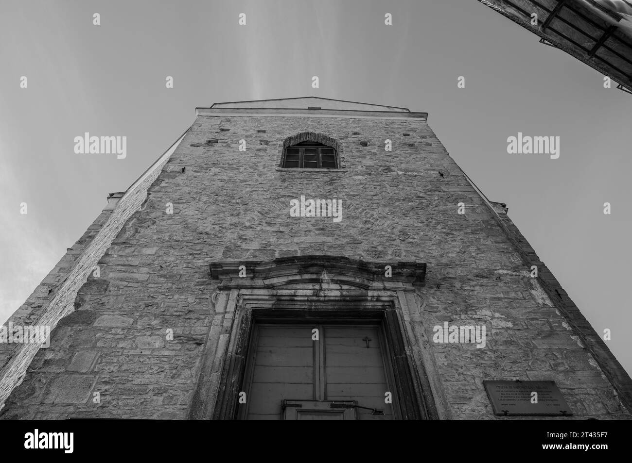 The façade is simple, in stone ashlars, with a portal decorated with a ...
