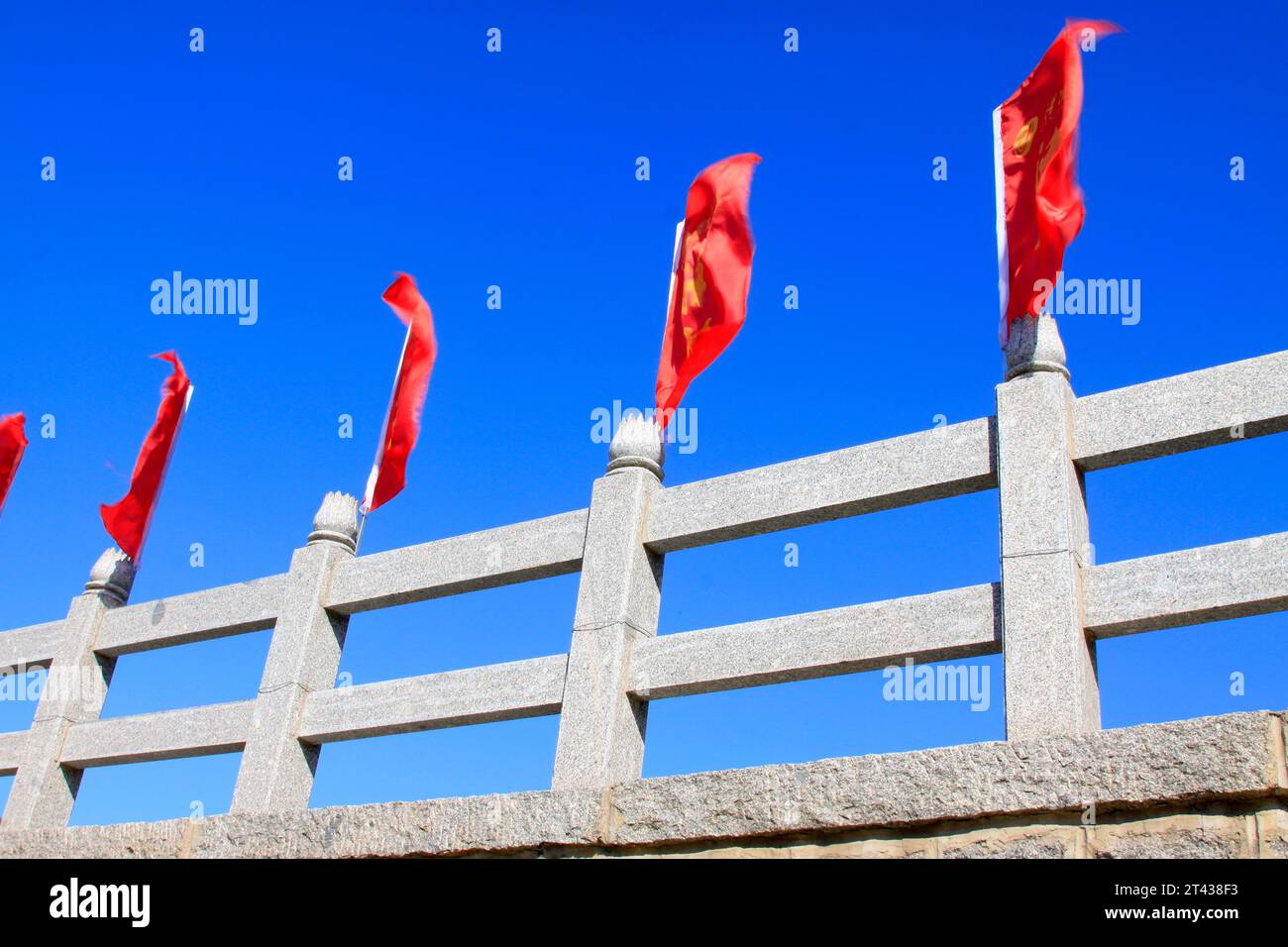 Rock railings and red flags, closeup of photo Stock Photo - Alamy