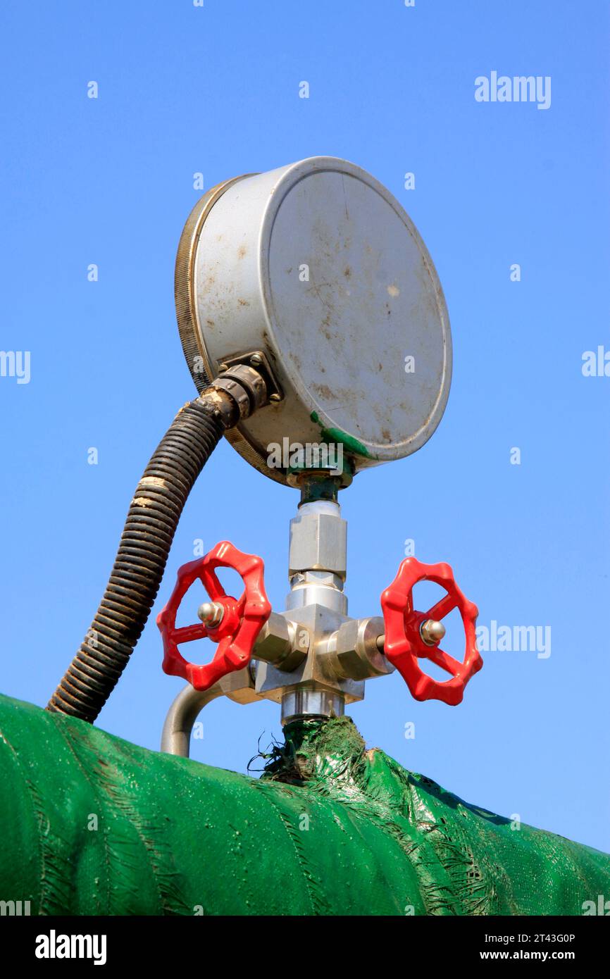 green oil pipelines and pressure gauge, closeup of photo Stock Photo ...