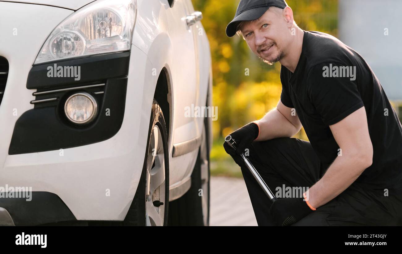 Man Unscrews Wheel On Car As Mechanic Stock Photo - Alamy