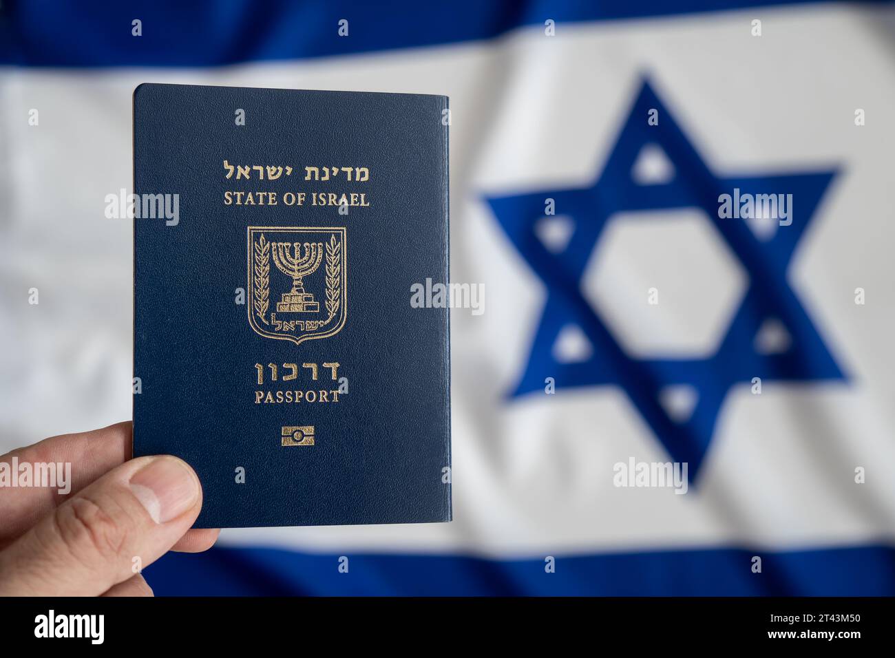 Male Hand holds an Israeli international passport with the blurred ...