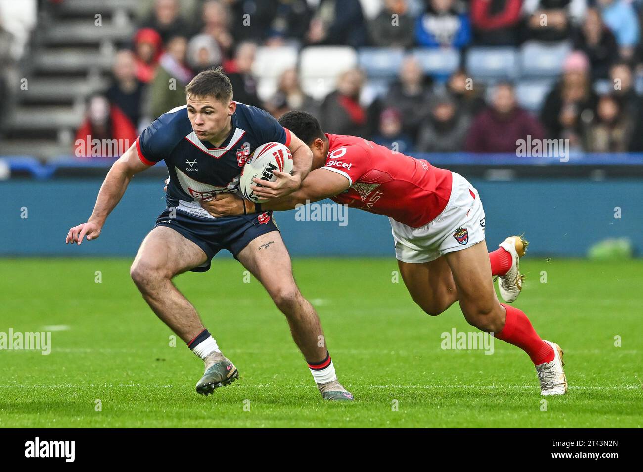 Jack Welsby of England evades the tackle of Will Penisini of Tonga ...