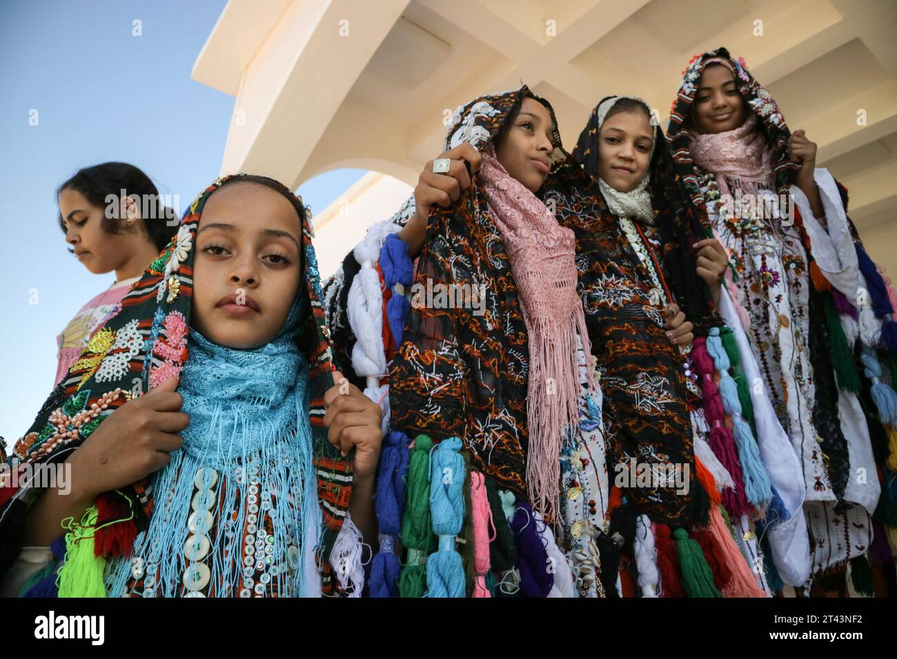 Young girls stand wearing the traditional women's costumes of Siwa ...