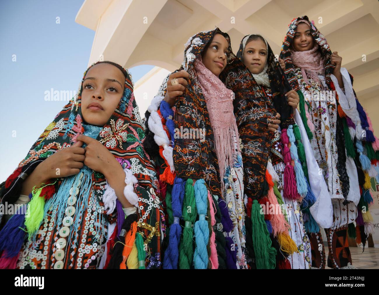 Young girls stand wearing the traditional women's costumes of Siwa ...