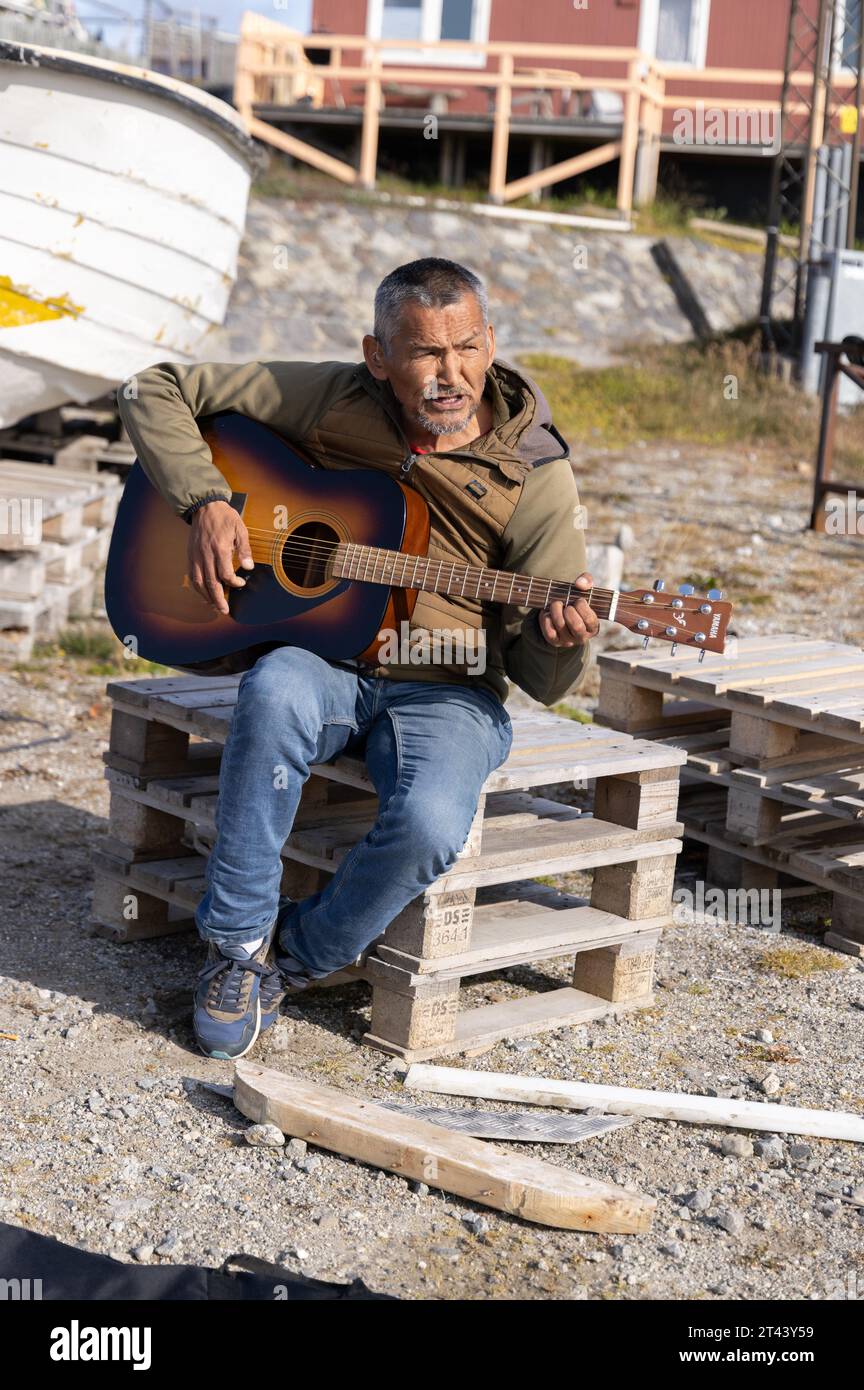 One male Street entertainer or musician playing guitar music ...