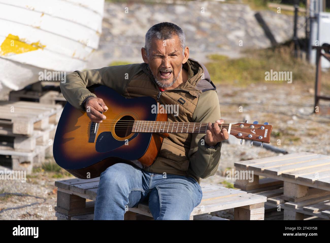 One male Street entertainer or musician playing guitar music ...