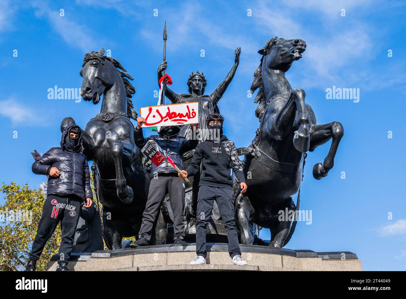 London, UK. 28th Oct, 2023. Protesters climb on the culpture of the ...