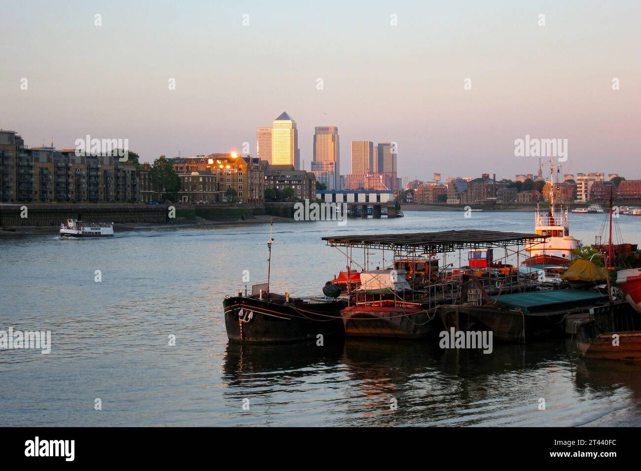 Boats moored on the bank of the Thames river with in the backgtround ...