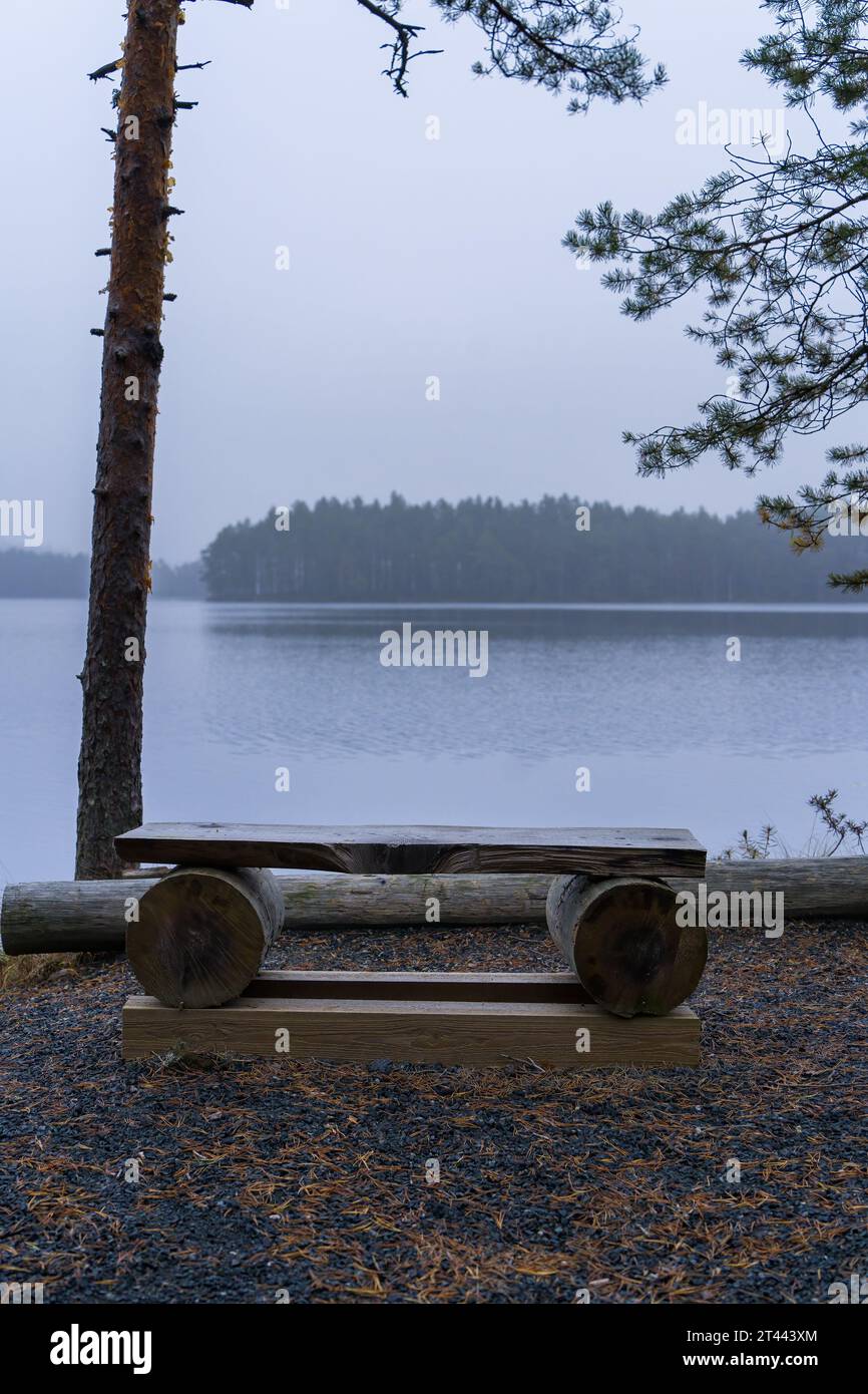 Wooden bench next to a blue misty lake in Komio Nature Reserve in ...