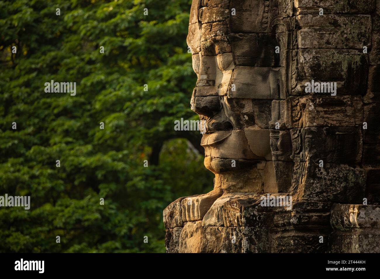 A huge face sculpted in stone, watches over visitors to the temple of ...