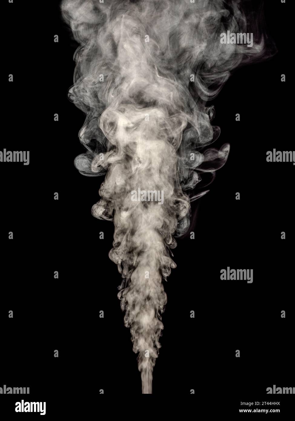 White smoke rises in a thick stream isolated on a black background ...