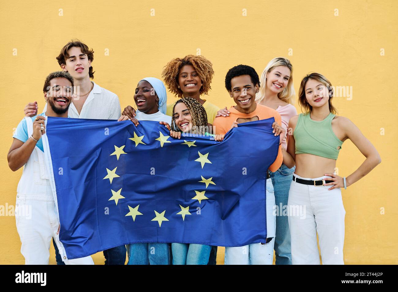 Multi-ethnic friends raising a European Union Flag Stock Photo - Alamy